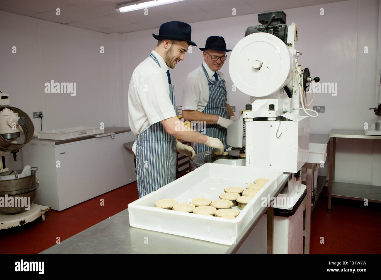 2 men working and making pork pies in a factory Stock Photo - Alamy