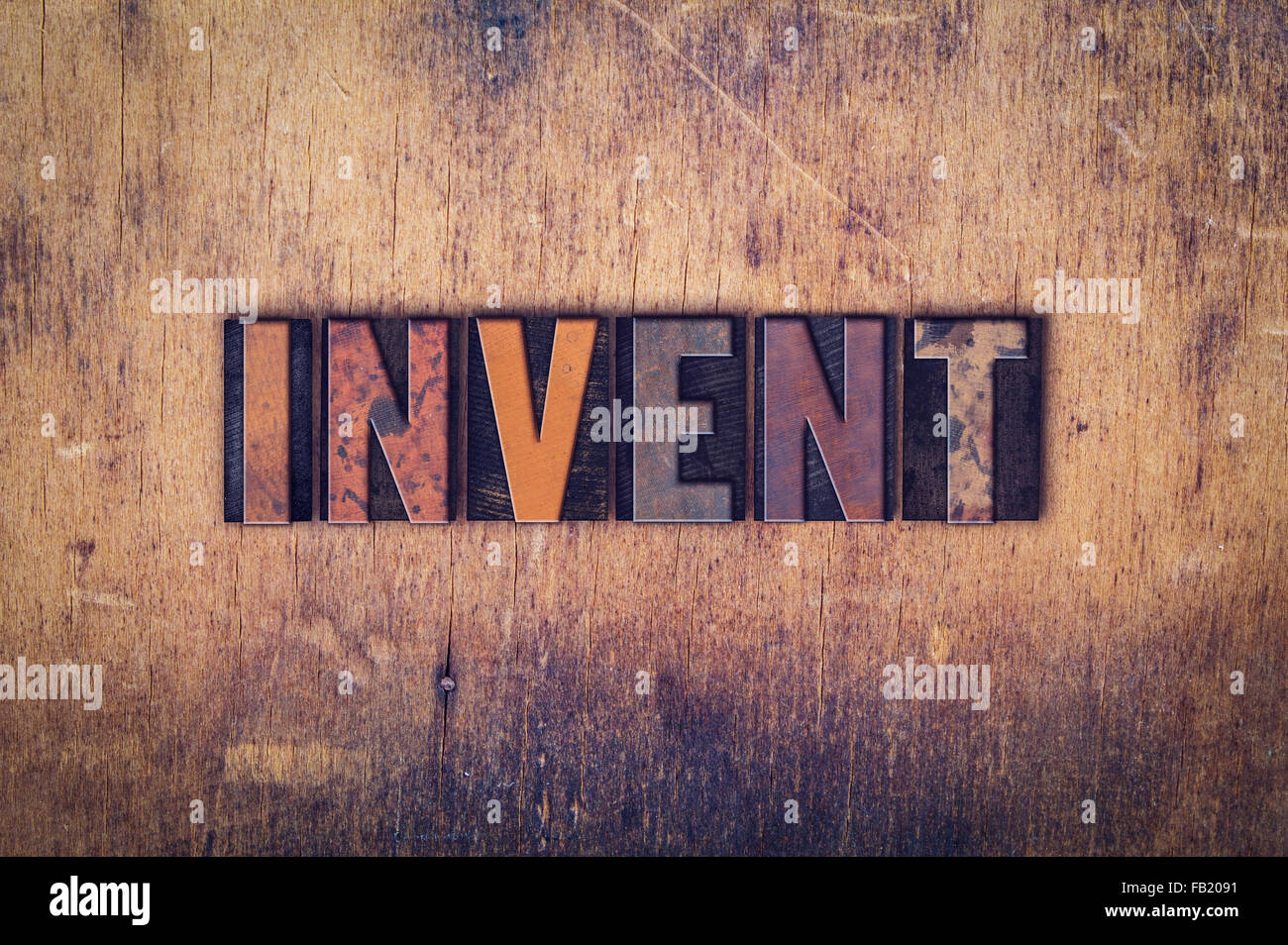 The word "Invent" written in dirty vintage letterpress type on a aged ...