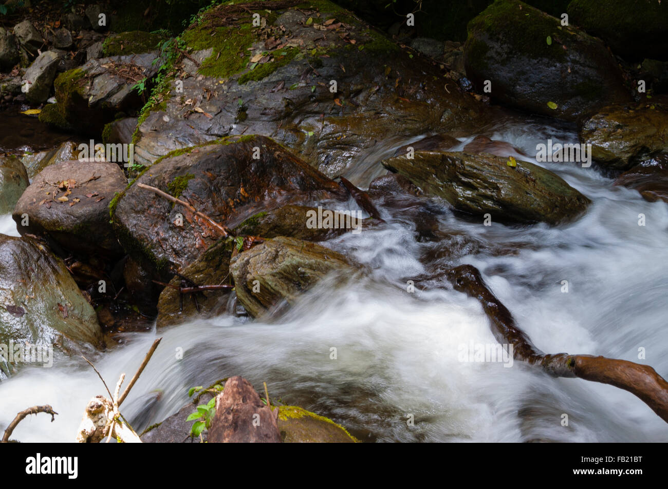 Closeup of water flowing around rocks with motion blur Stock Photo - Alamy