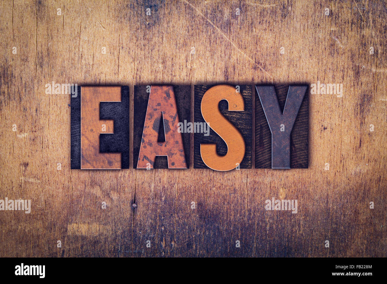 The word "Easy" written in dirty vintage letterpress type on a aged ...