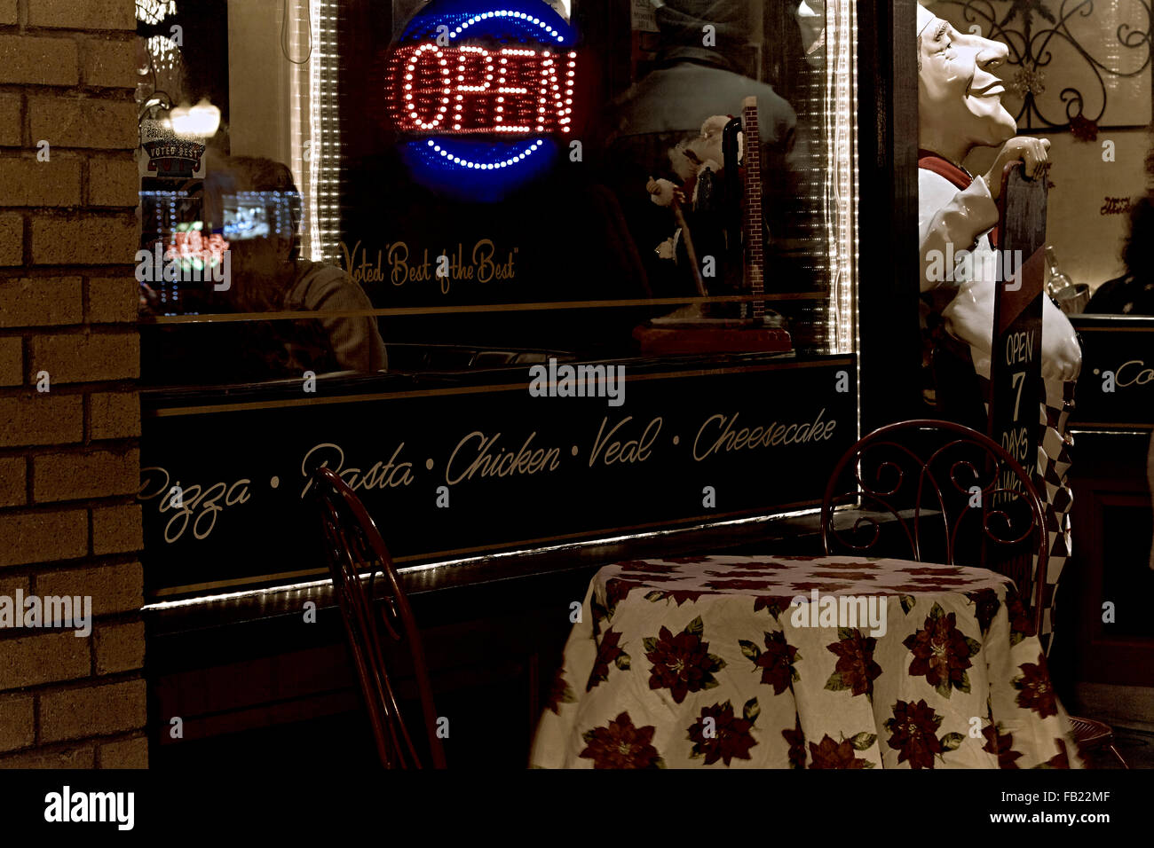 Storefront window of a restuarant with table and chairs outside and a ...