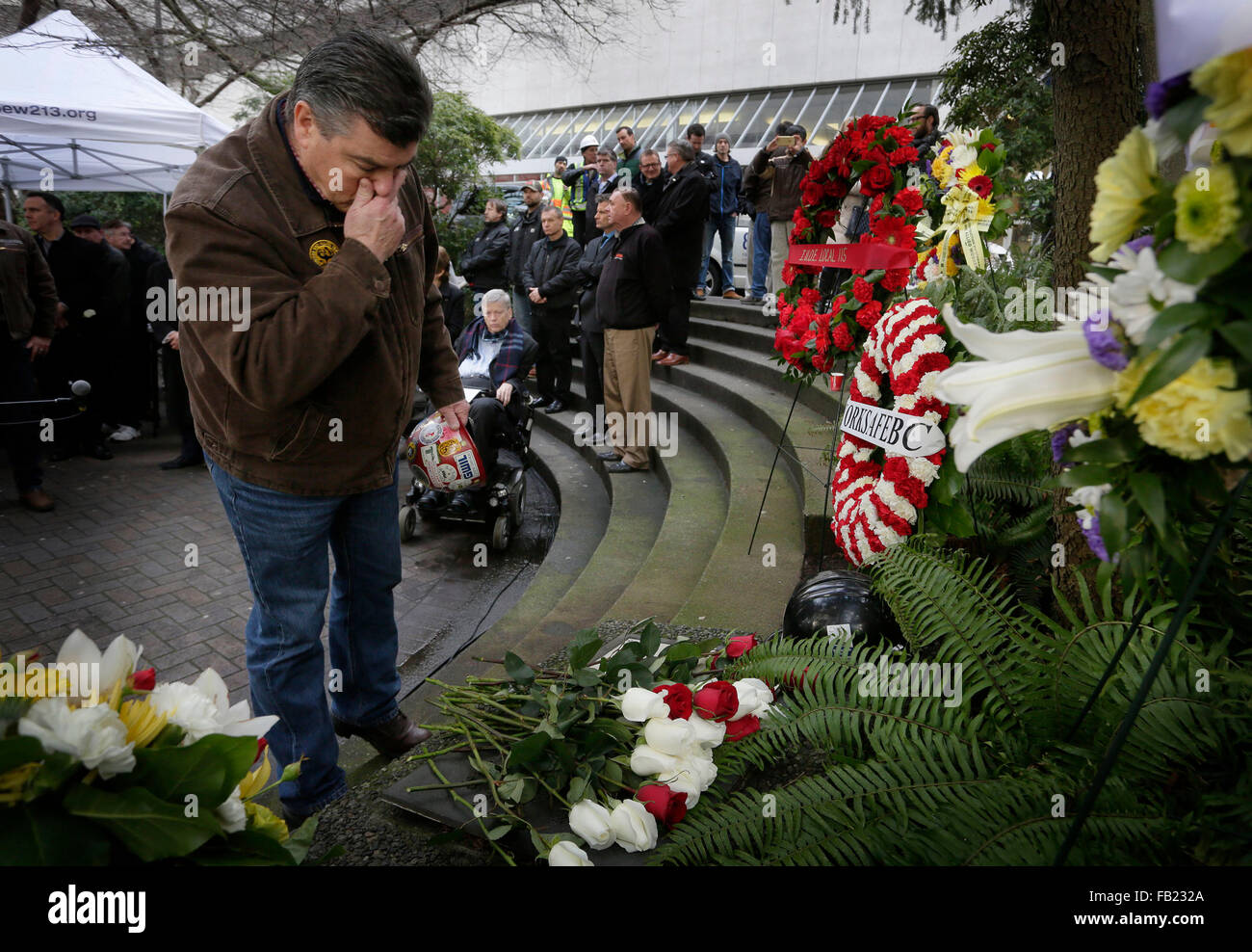 Vancouver, Canada. 7th Jan, 2016. A construction worker lays a flower ...