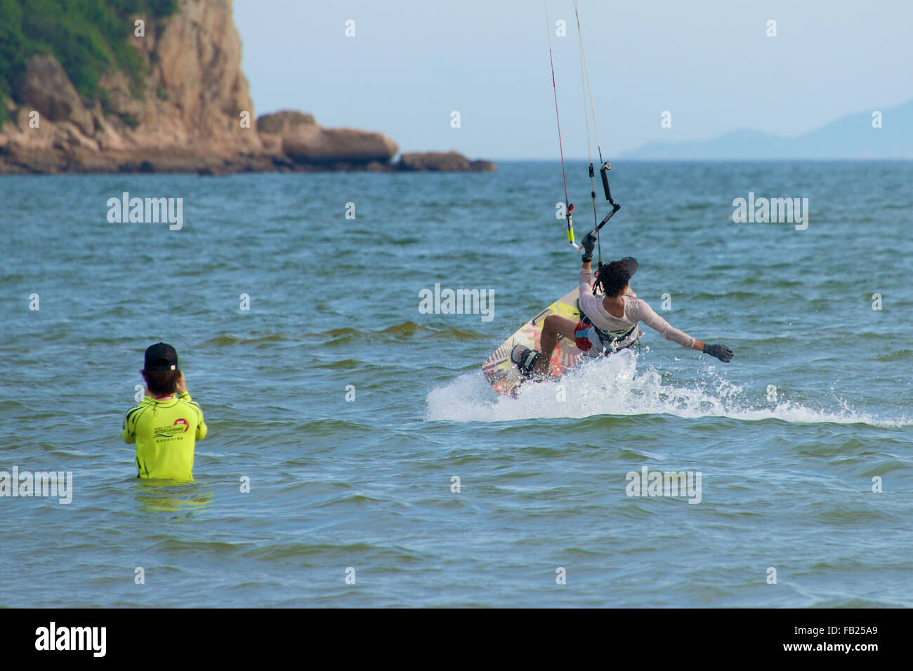 Male kite surfer jumping for a photographer Stock Photo - Alamy