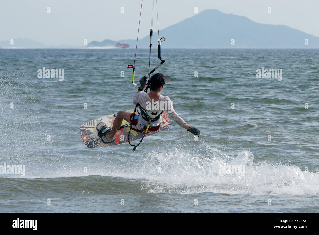 Male kite surfer jumping with ferry behind Stock Photo - Alamy