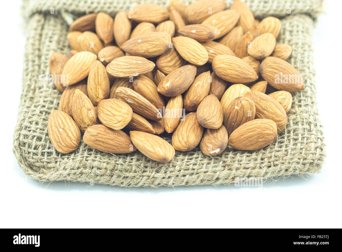 Almonds on the sack isolated on white background Stock Photo - Alamy