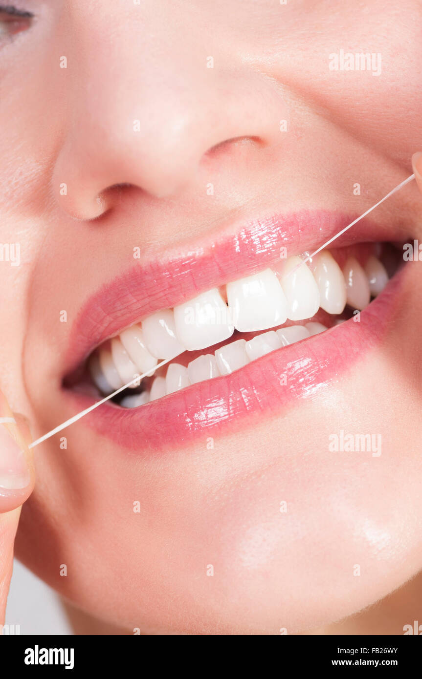 Young woman flossing her clean white teeth Stock Photo - Alamy
