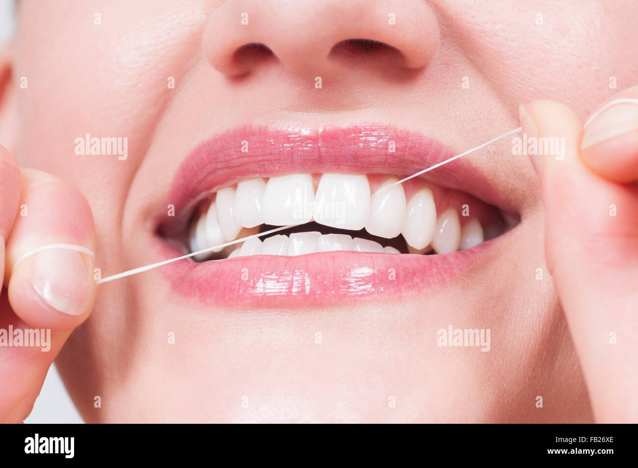 Young woman flossing her clean white teeth Stock Photo - Alamy