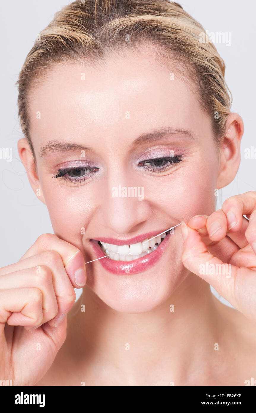 Young woman flossing her clean white teeth Stock Photo - Alamy