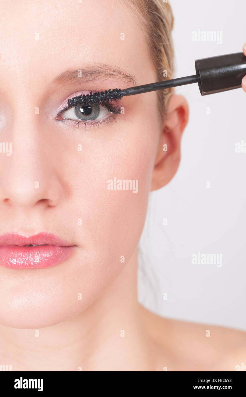 Close up of a young woman applying mascara to eyelashes Stock Photo - Alamy