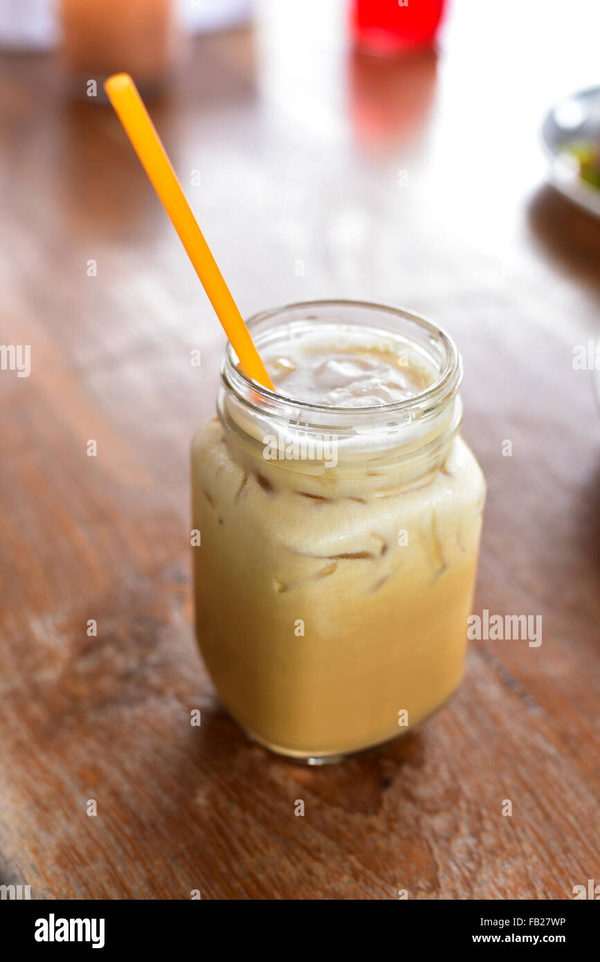 Cold ice coffee on wooden table in summer Stock Photo - Alamy