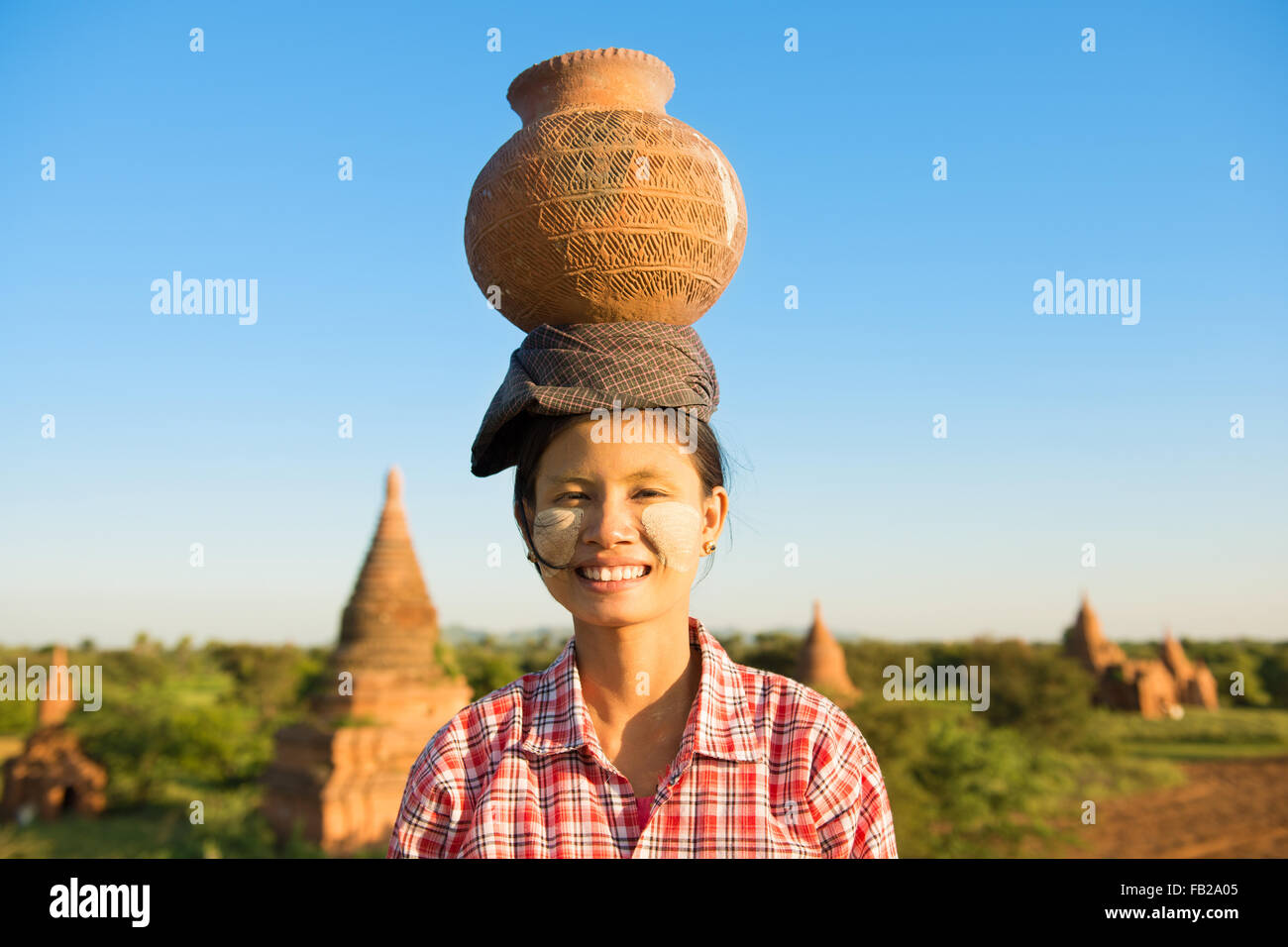 Portrait of Young Asian traditional female farmer carrying clay pot on ...