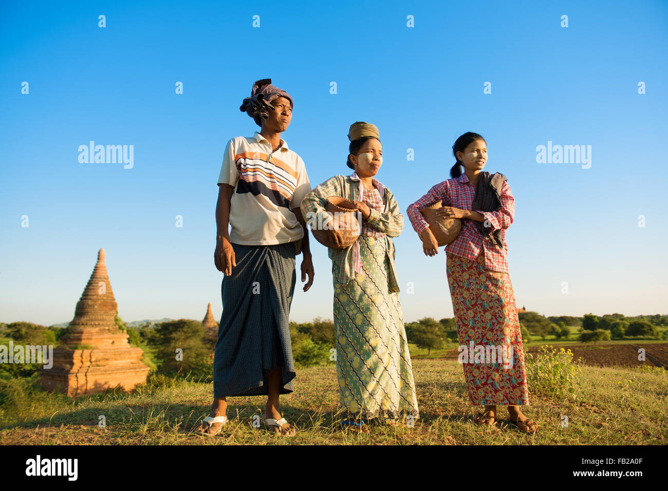 Group of Asian Burmese traditional farmers carrying clay pots going ...