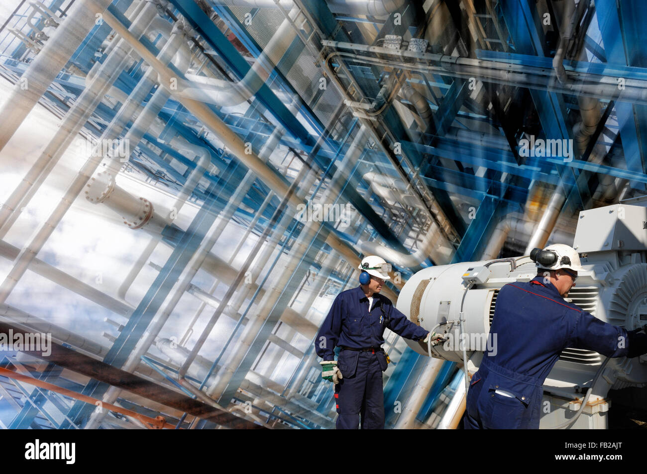 oil workers inside refinery with large pipelines Stock Photo - Alamy