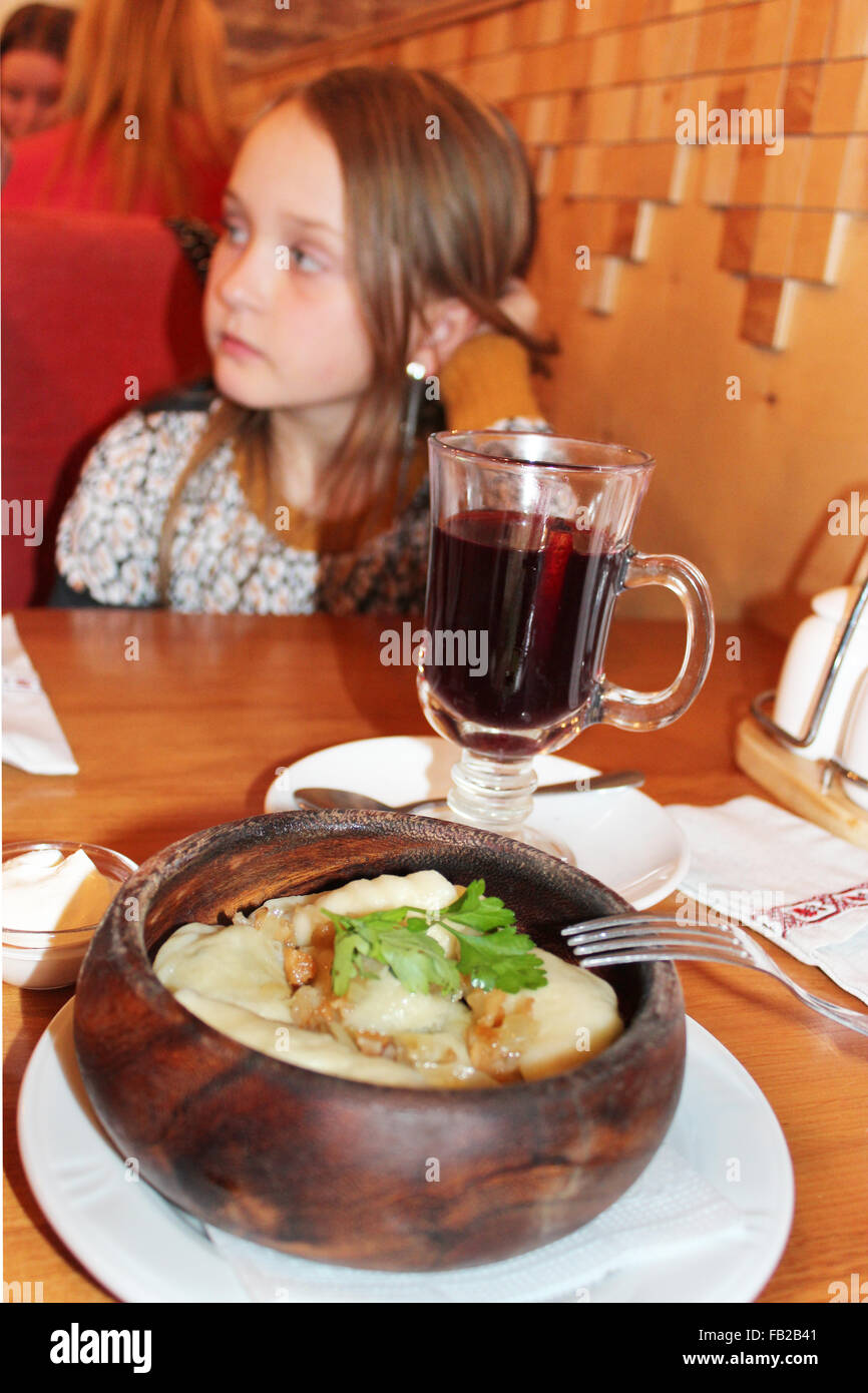 young girl in the restaurant. varenyky with fried slices of bacon ...