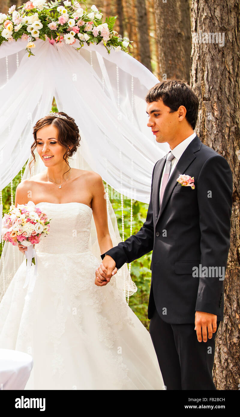 Cheerful married couple standing near the wedding arch Stock Photo - Alamy