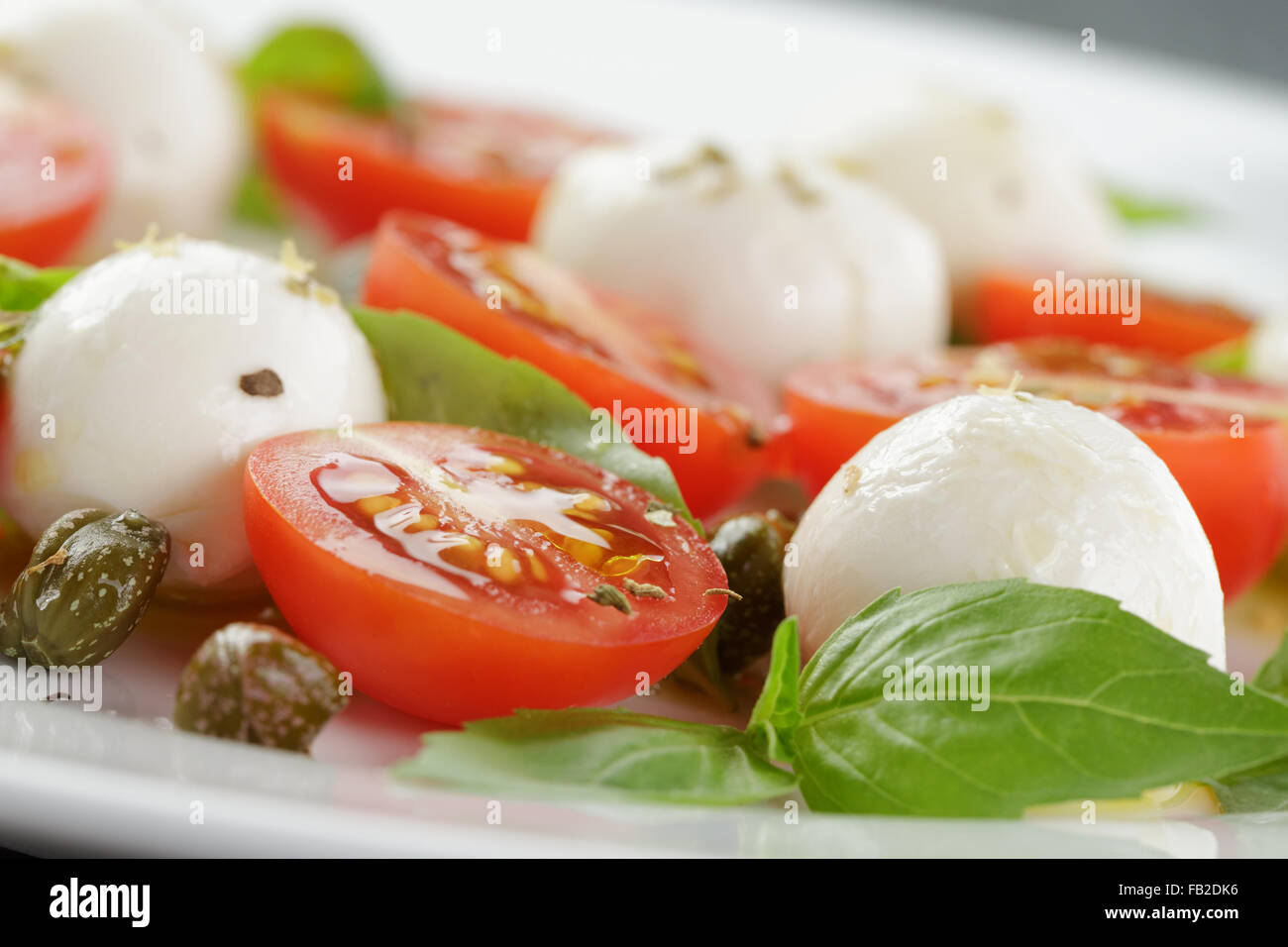 caprese salad with mini mozzarella balls, tomatoes and capers Stock ...