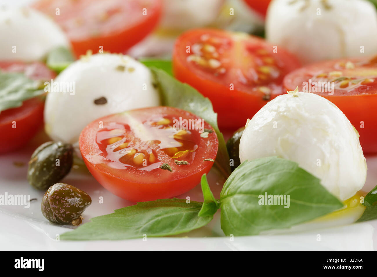 caprese salad with mini mozzarella balls, tomatoes and capers Stock ...