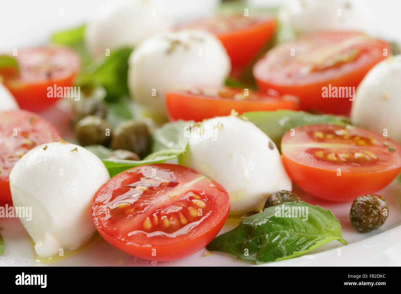 caprese salad with mini mozzarella balls, tomatoes and capers Stock ...
