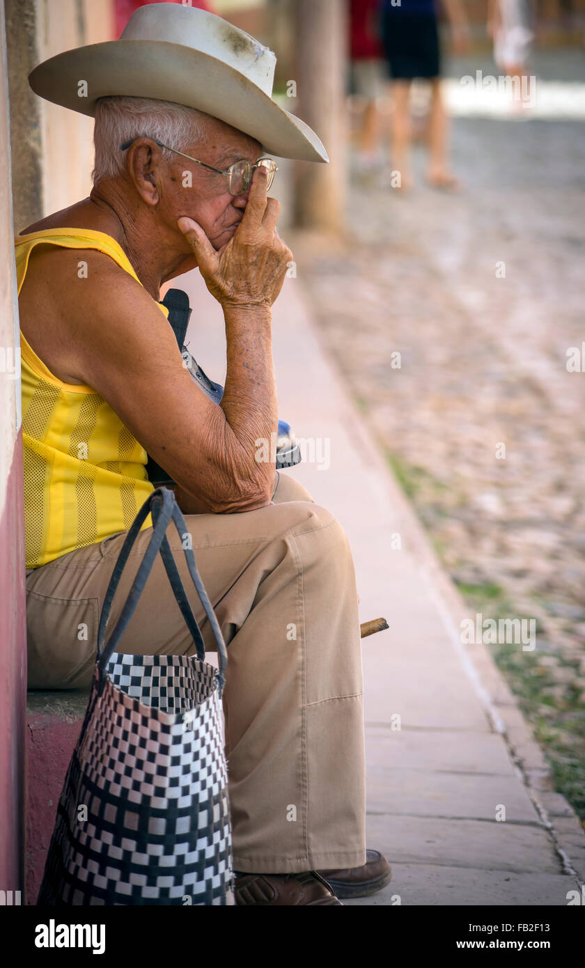 Cuban man sitting on the street in Trinidad, Cuba Stock Photo - Alamy