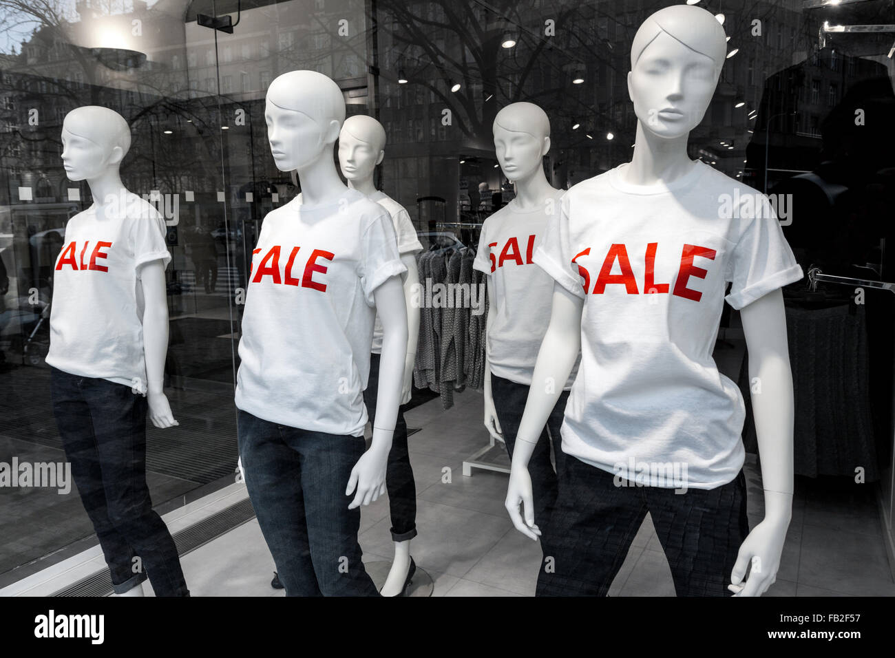 Window display with five mannequins wearing t-shirts with text Sale ...