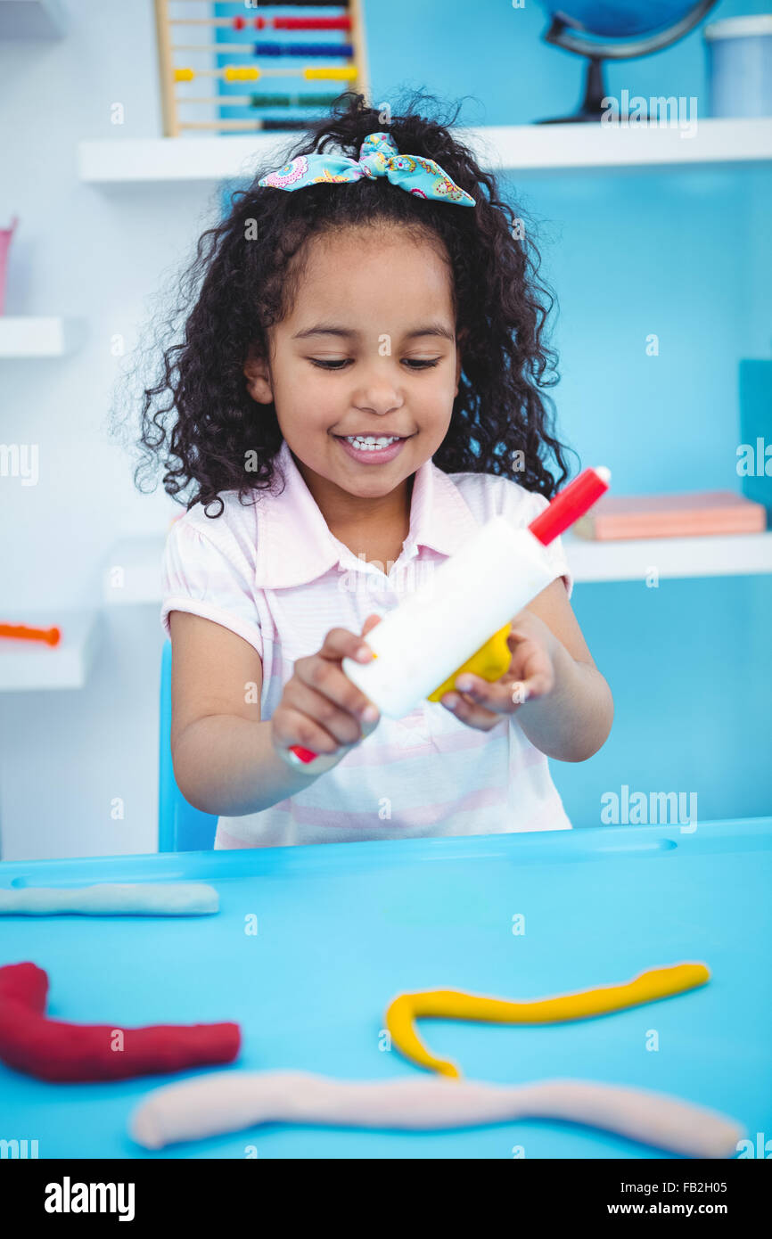 Cute girl using modeling clay Stock Photo - Alamy