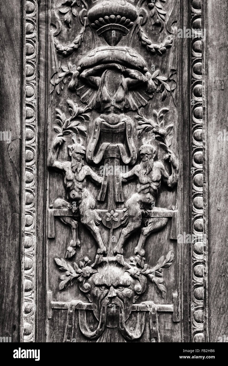 Detail of old wooden gate engraved with demonic figures Stock Photo - Alamy