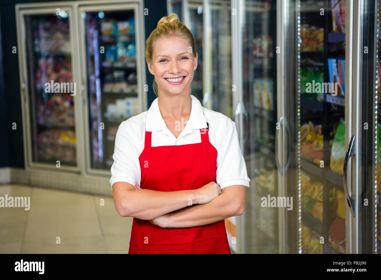 Smiling shop assistant with arms crossed Stock Photo - Alamy