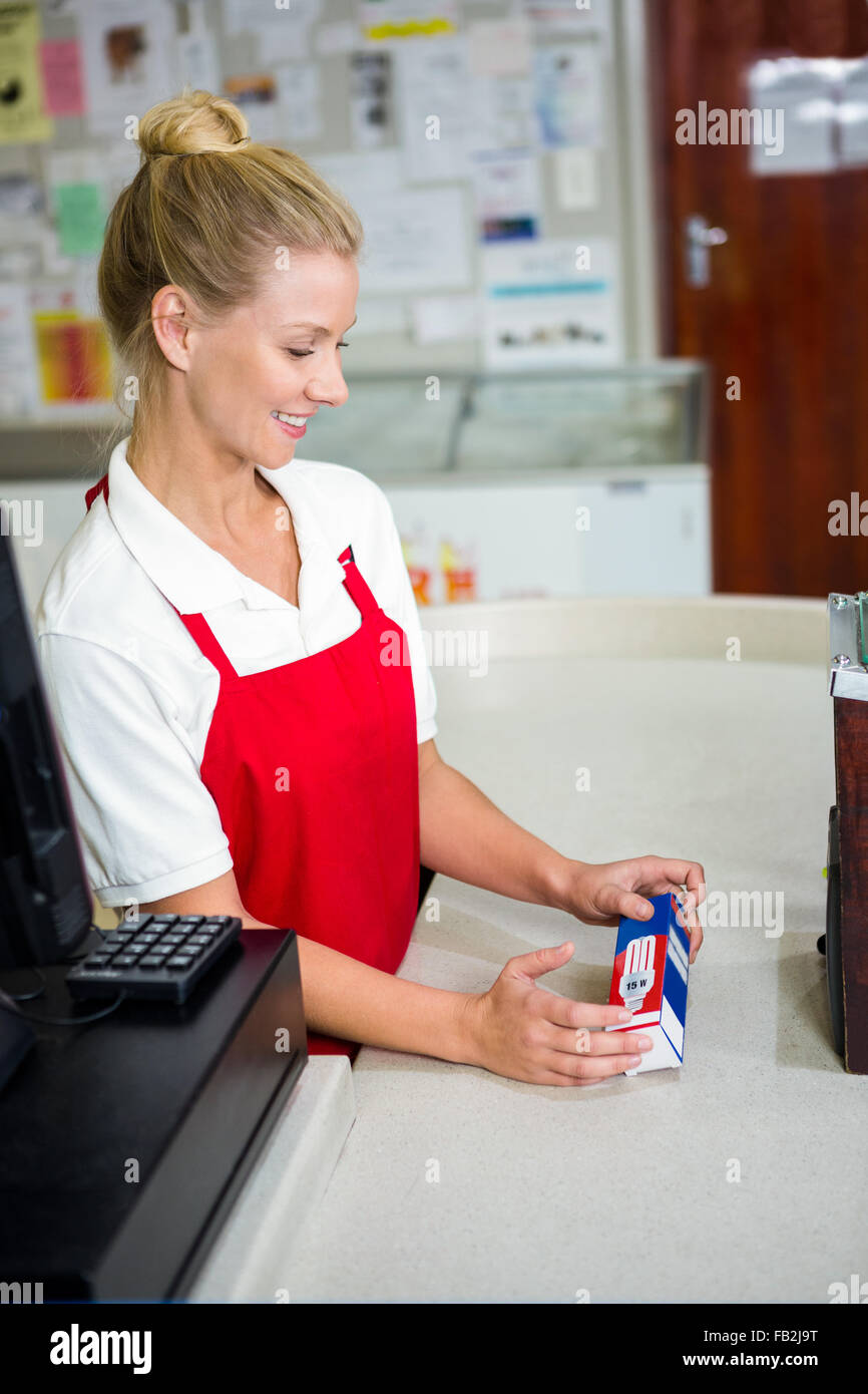 Smiling shop assistant looking at product Stock Photo - Alamy