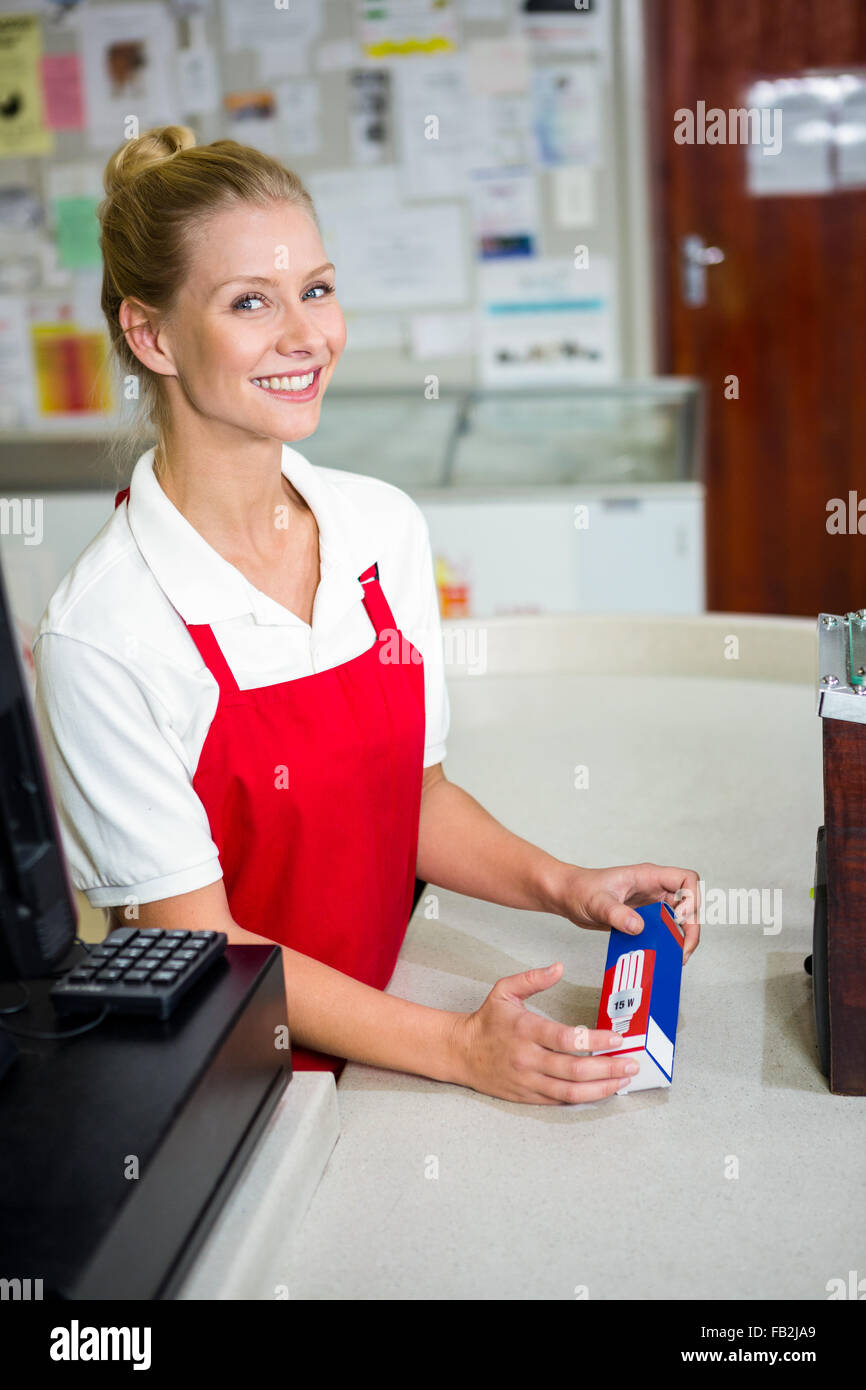Smiling shop assistant looking at product Stock Photo - Alamy