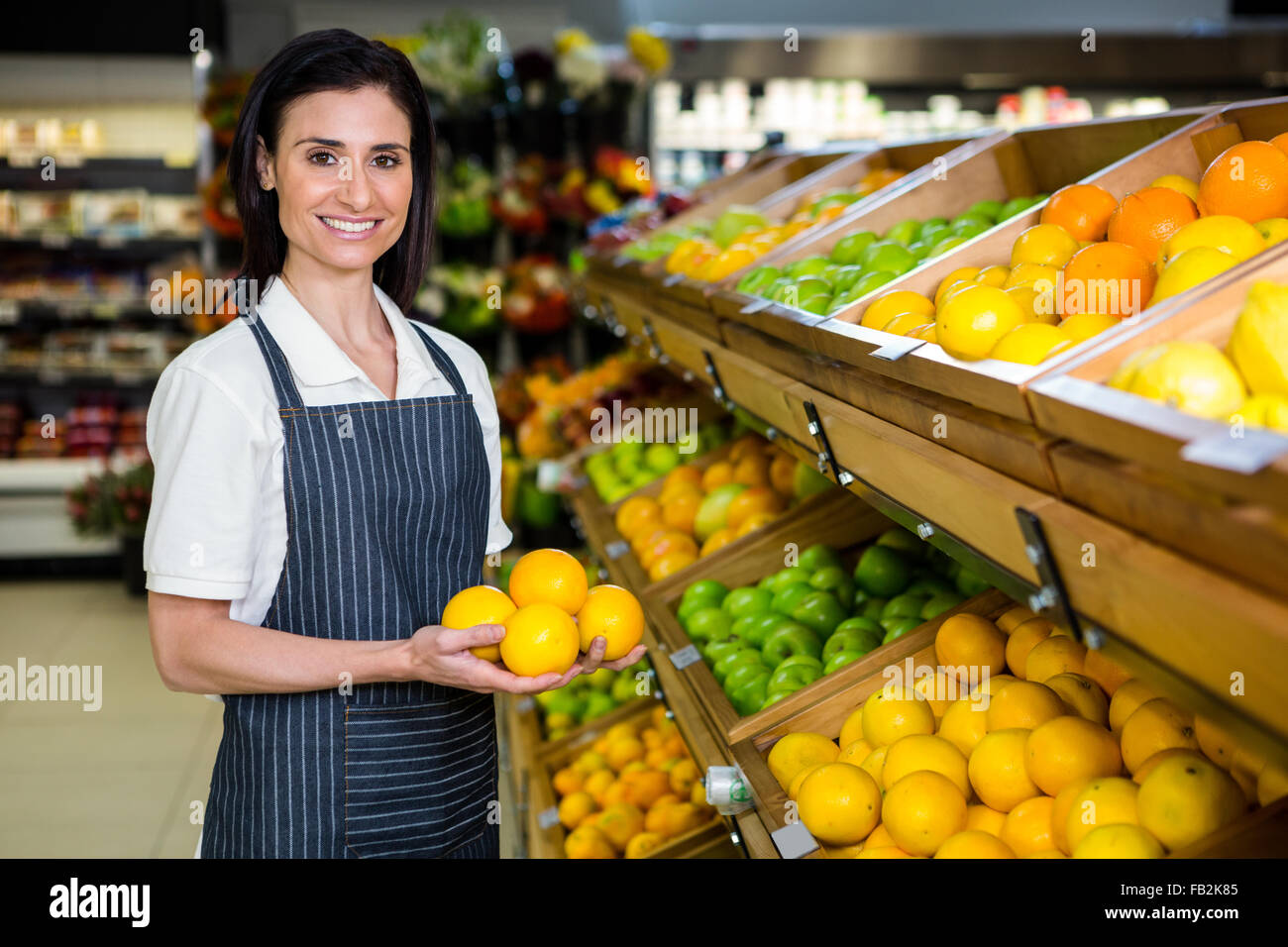 Portrait of a smiling worker taking a fruits Stock Photo - Alamy