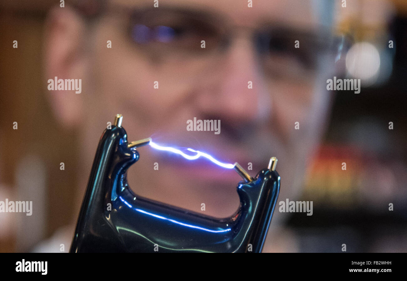 Weapons dealer Andreas Engels holds up a stun gun at his shop in ...