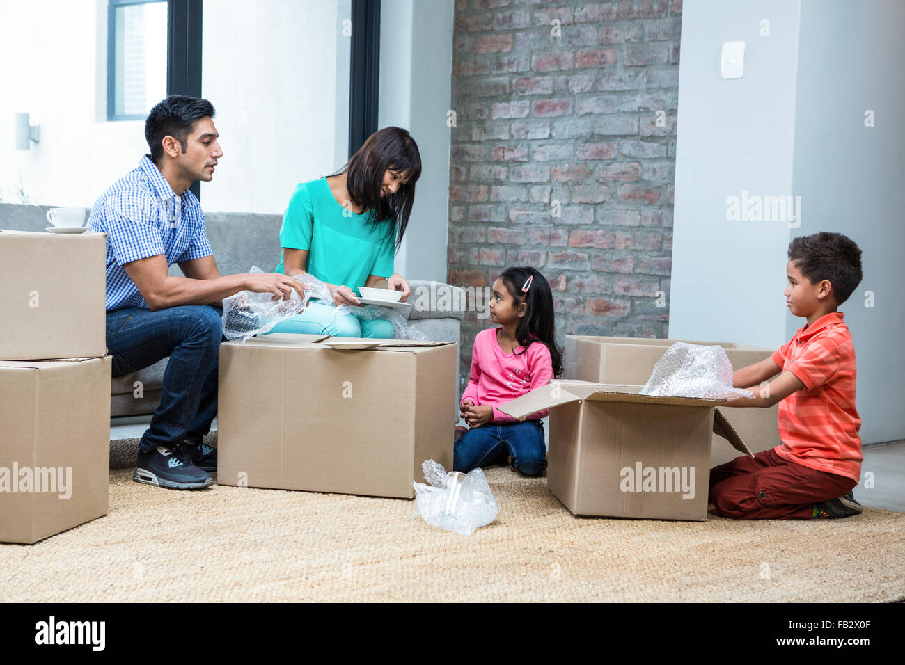 Happy family opening boxes Stock Photo - Alamy