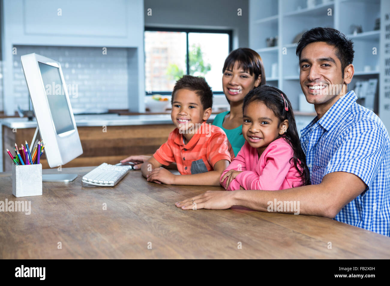 Happy family using computer in the kitchen Stock Photo - Alamy