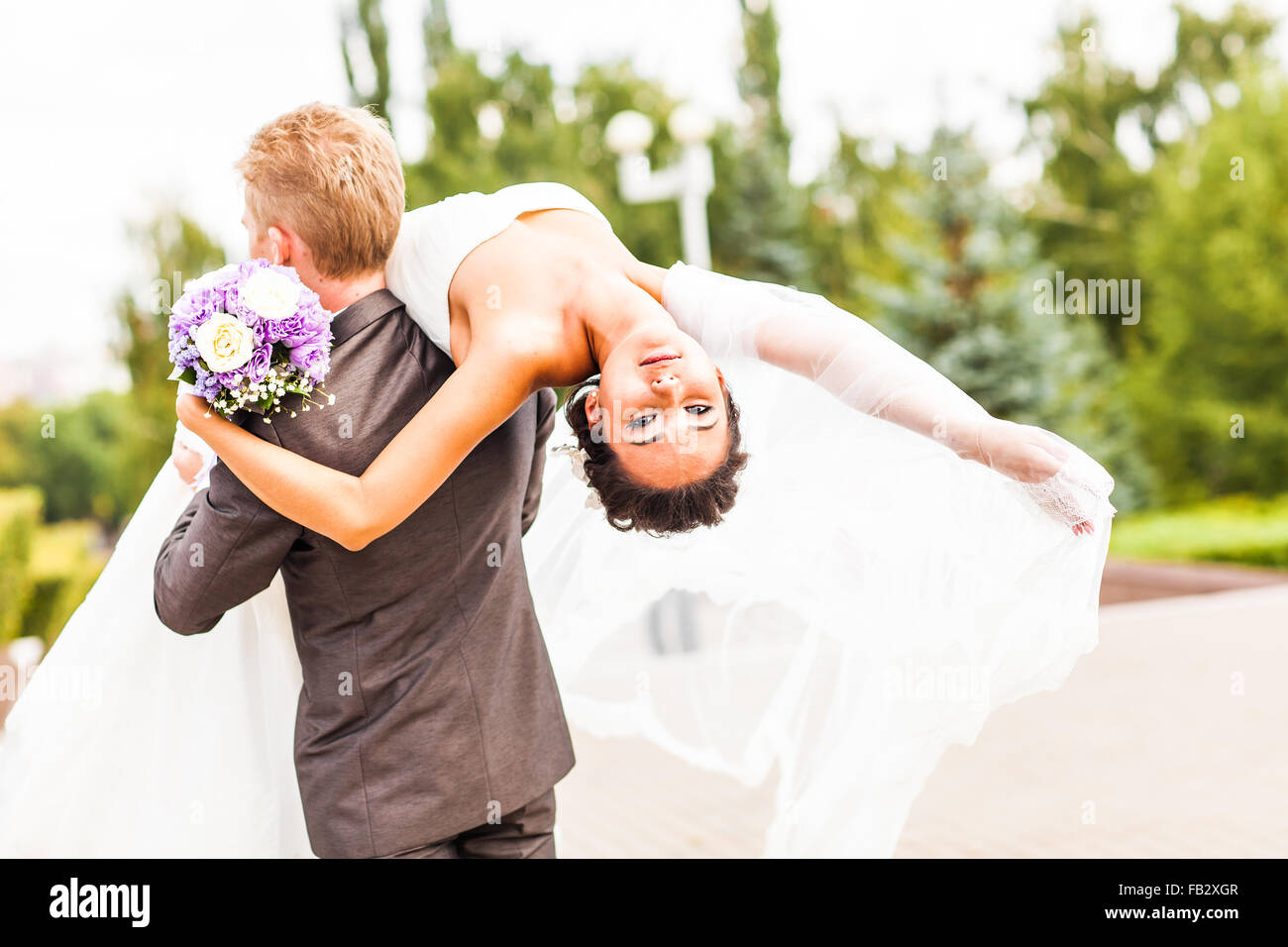 Groom holding bride in dance pose on wedding day Stock Photo - Alamy