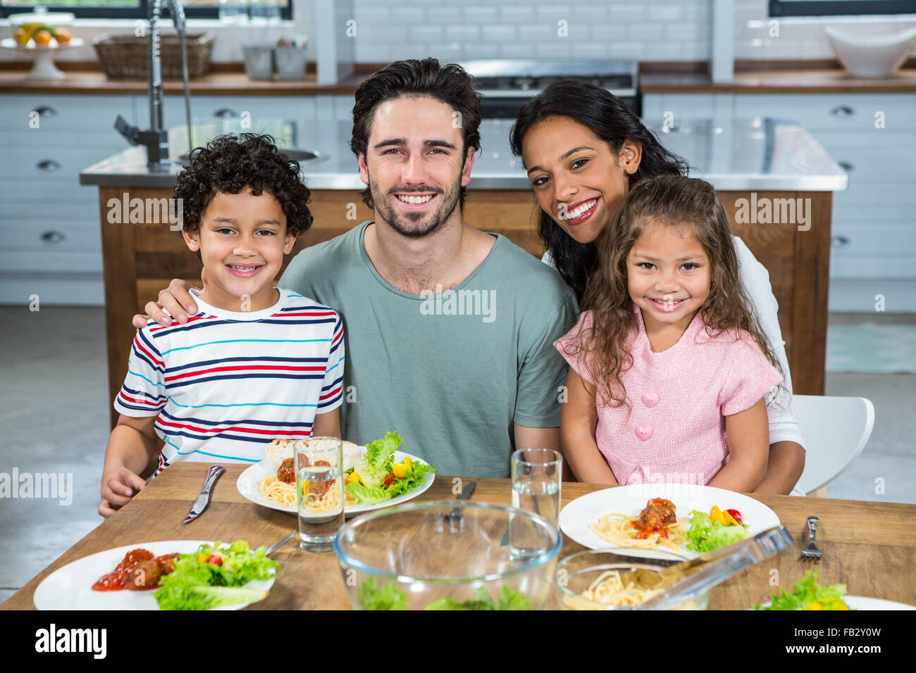 Happy family eating together in the kitchen Stock Photo - Alamy