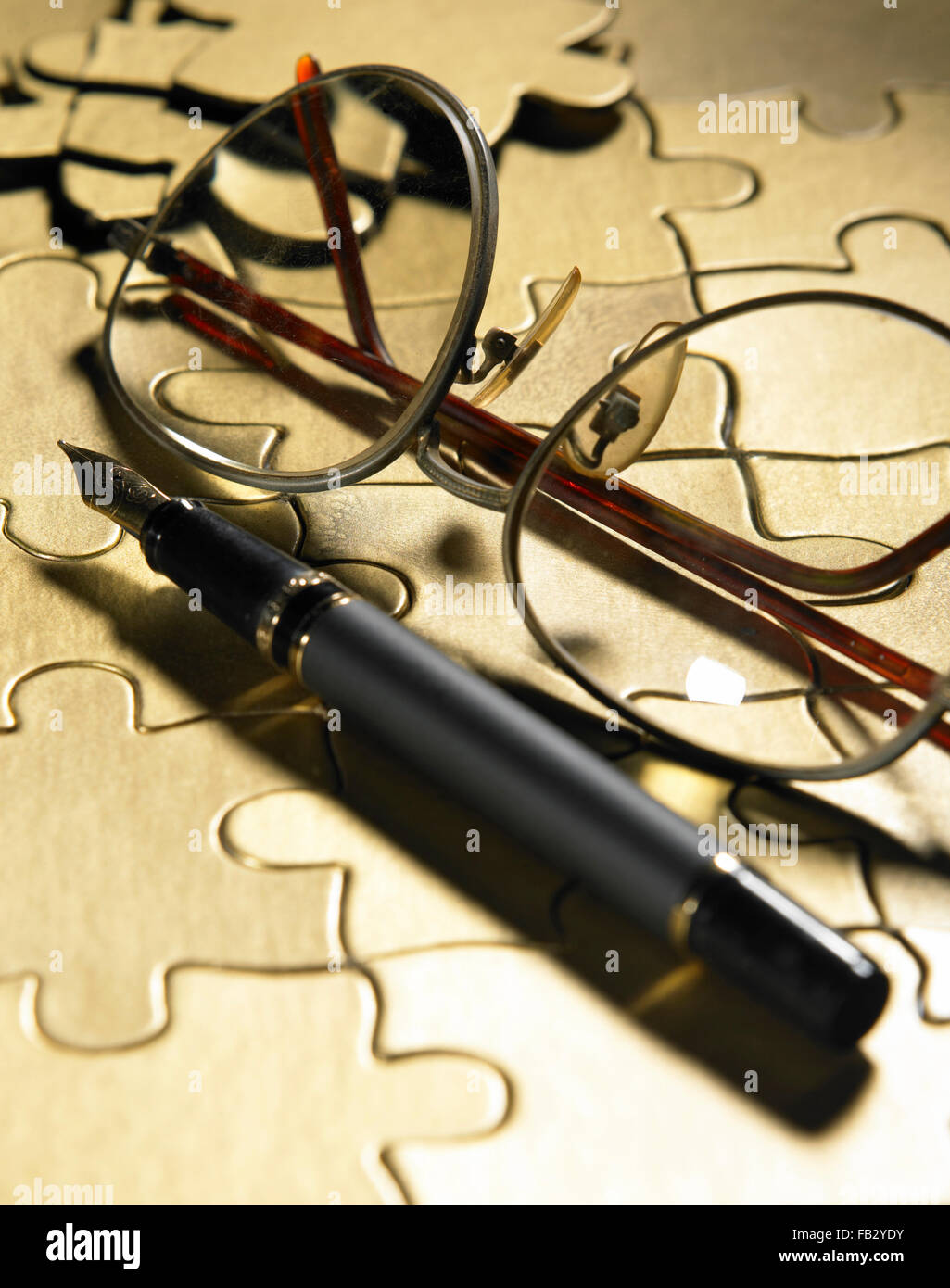 pen and a pair of the glasses on the puzzle Stock Photo - Alamy