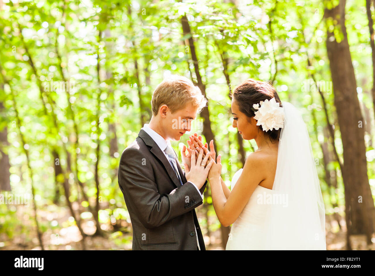 wedding couple hugging, the bride holding a bouquet of flowers in her ...