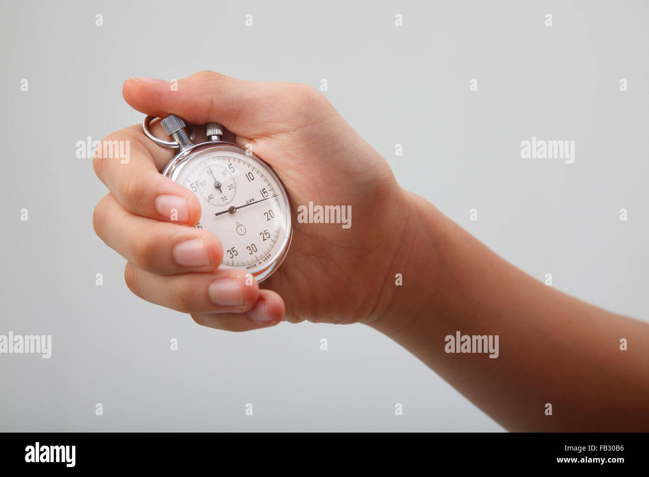 man holding a stop watch on the plain background Stock Photo - Alamy