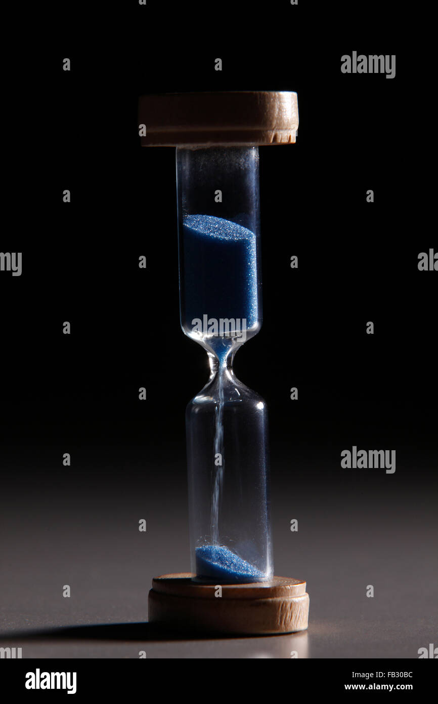 Hourglass - Grains of sand falling down Stock Photo - Alamy