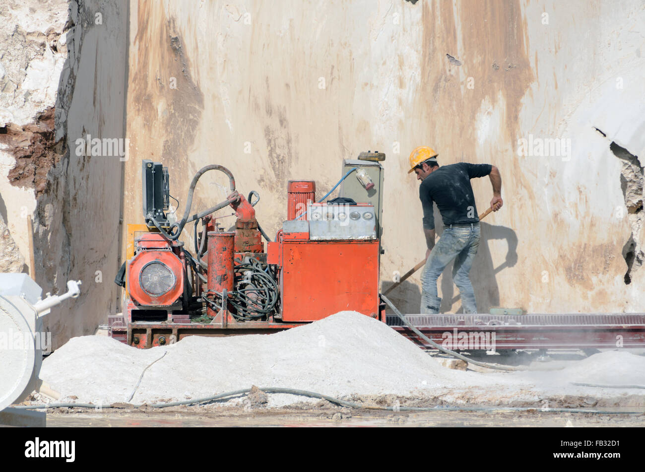 Industrial marble quarry, with cut blocks and workers and machines at ...