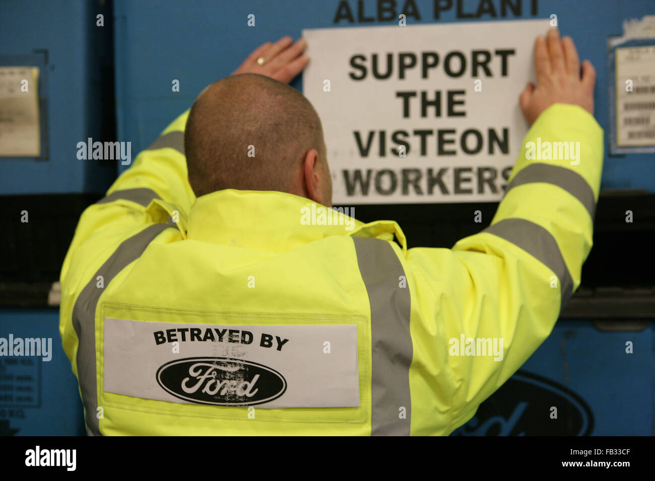 A sit-in worker put up signs for support during a tour of the Visteon ...