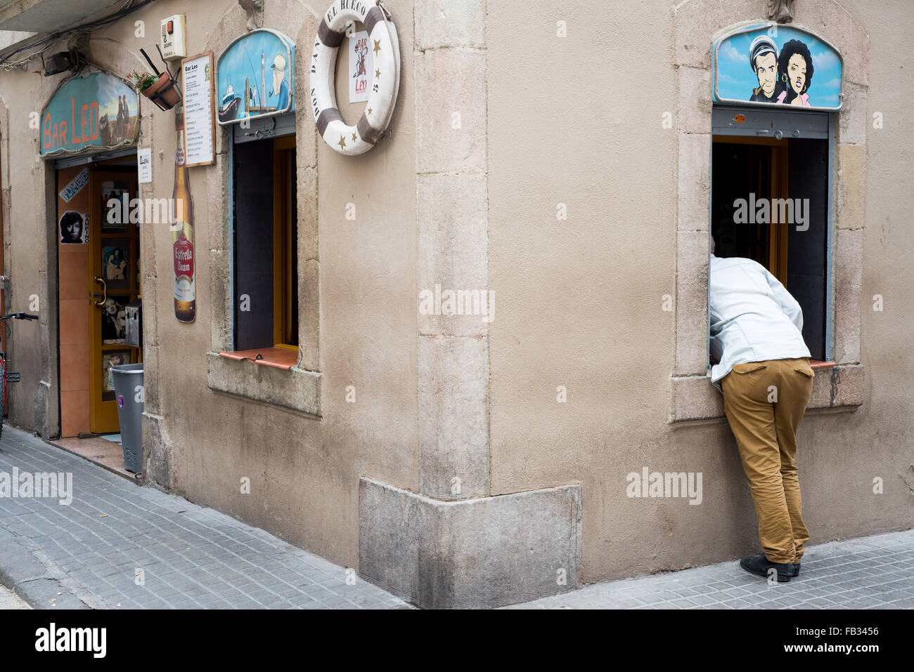 A man poke in a bar from a window in Barcelona Stock Photo - Alamy