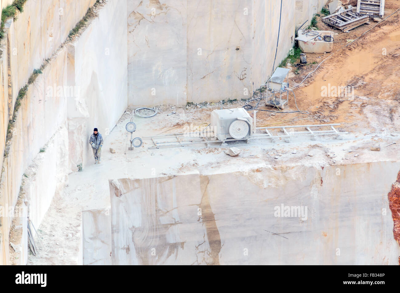 Industrial marble quarry, with cut blocks and workers and machines ...