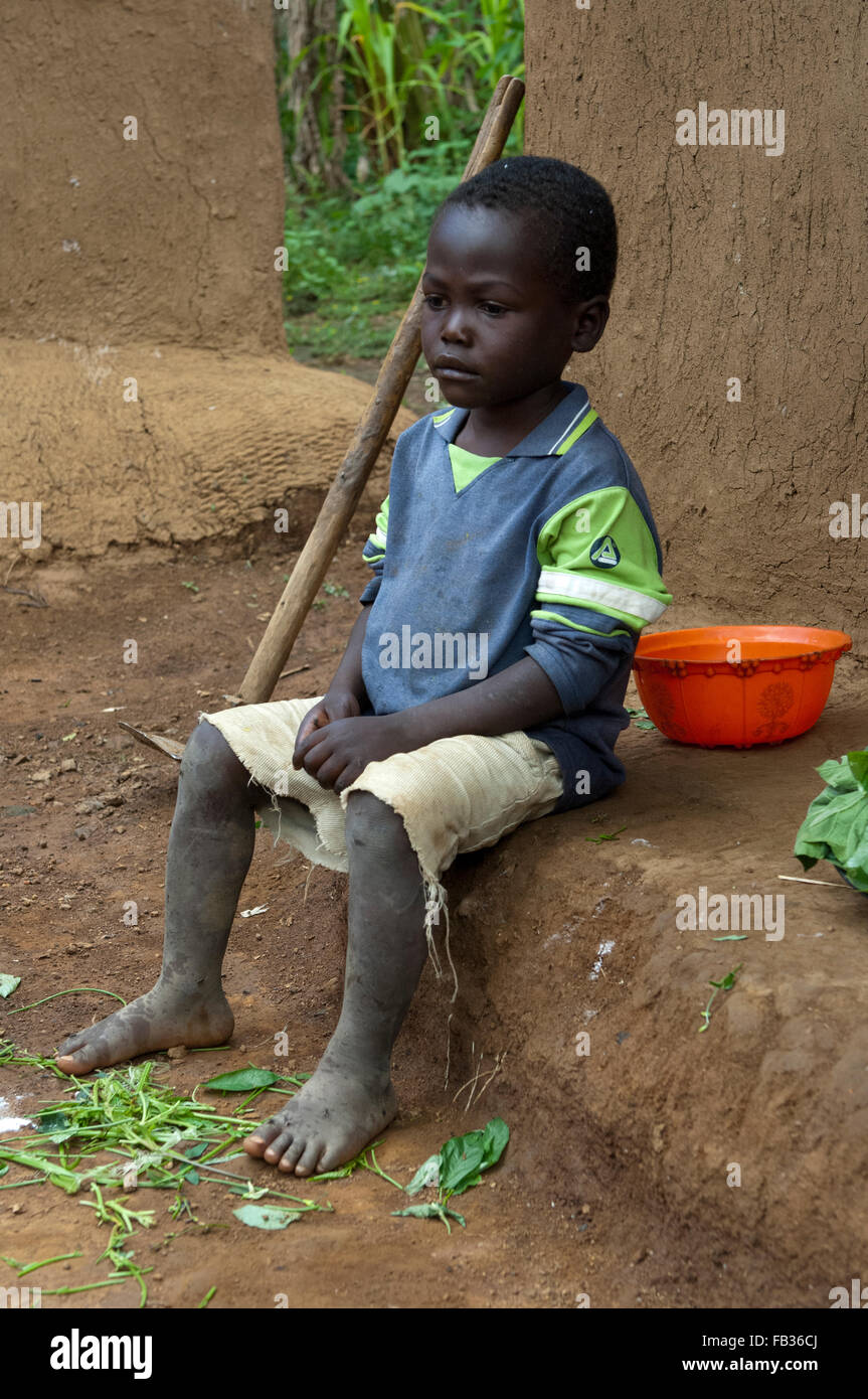 Young boy sitting outside his home, showing signs of poverty. Kenya ...