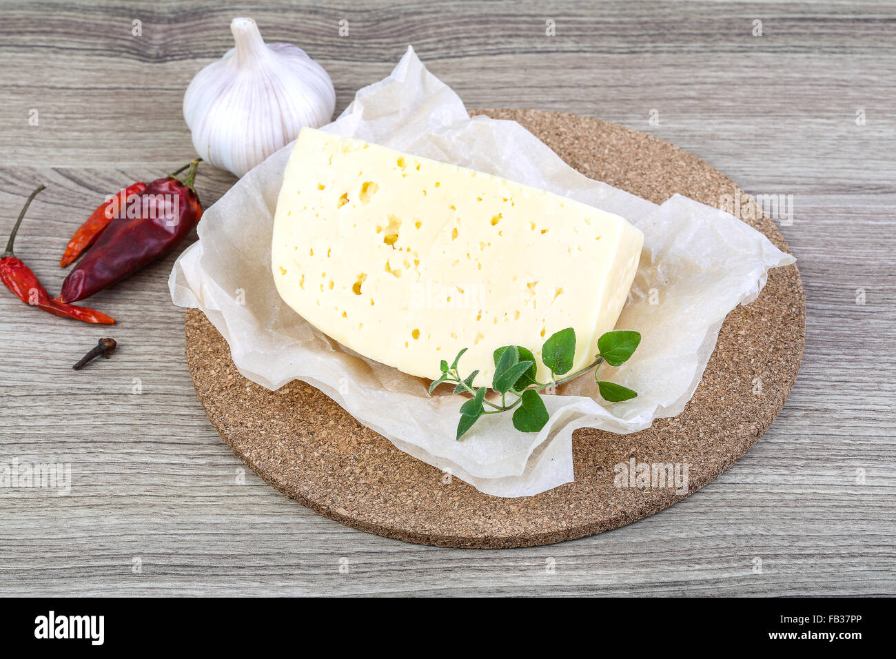Part of round cheese on the wood background with herbs Stock Photo - Alamy