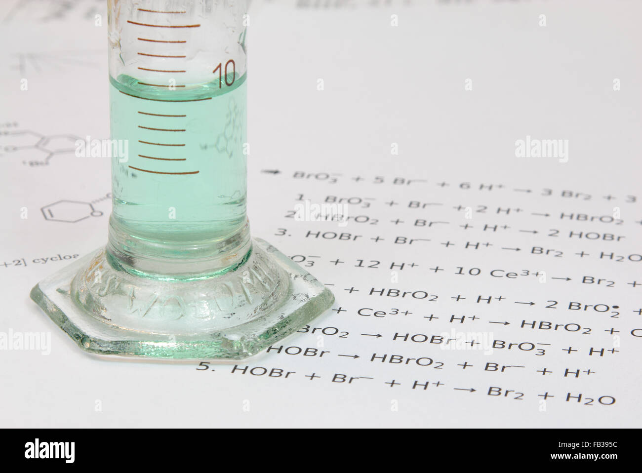 Measuring cylinder on a sheet with chemical reaction Stock Photo - Alamy