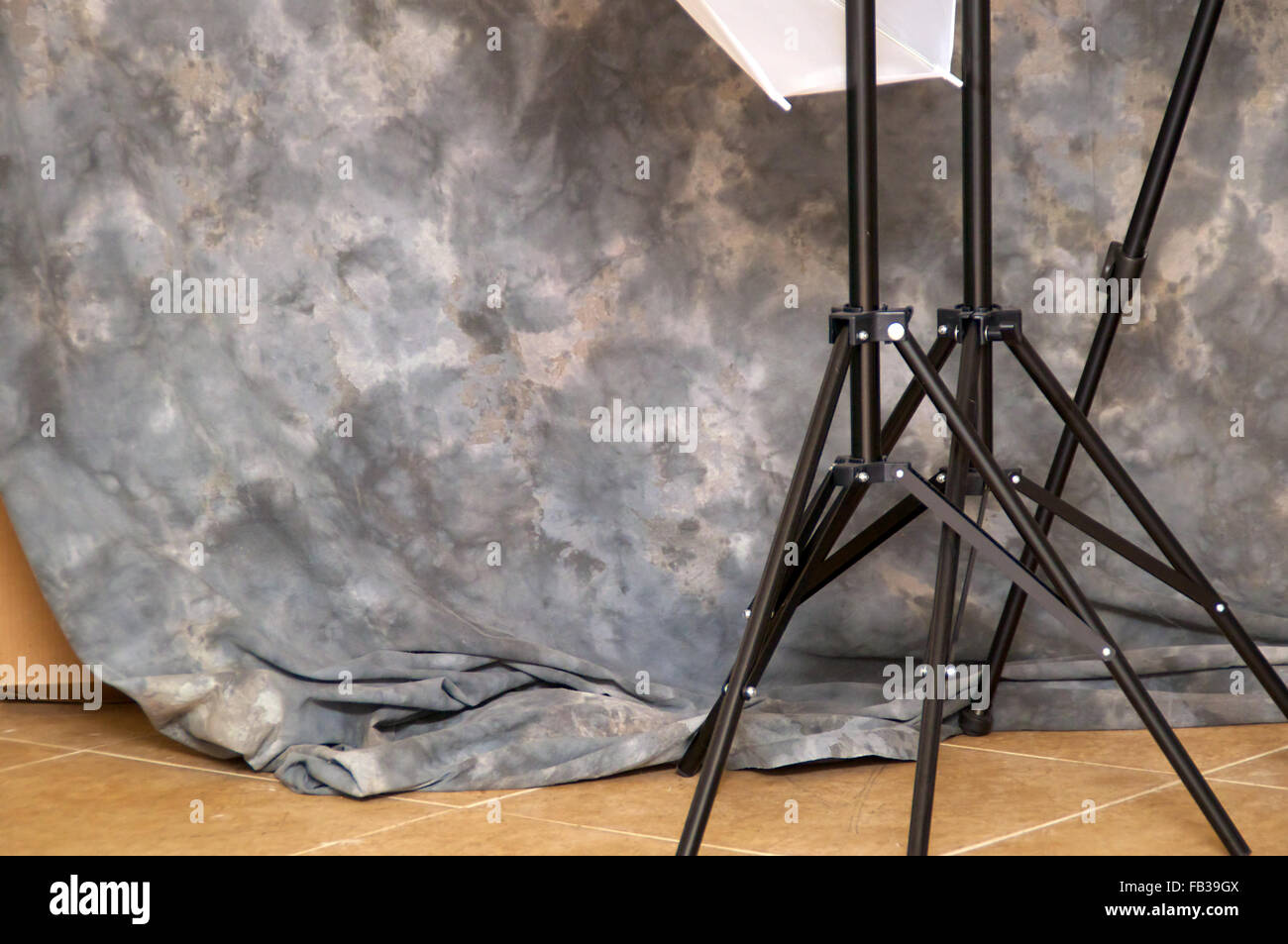 View behind the scenes of mottled background and light stand tripod ...