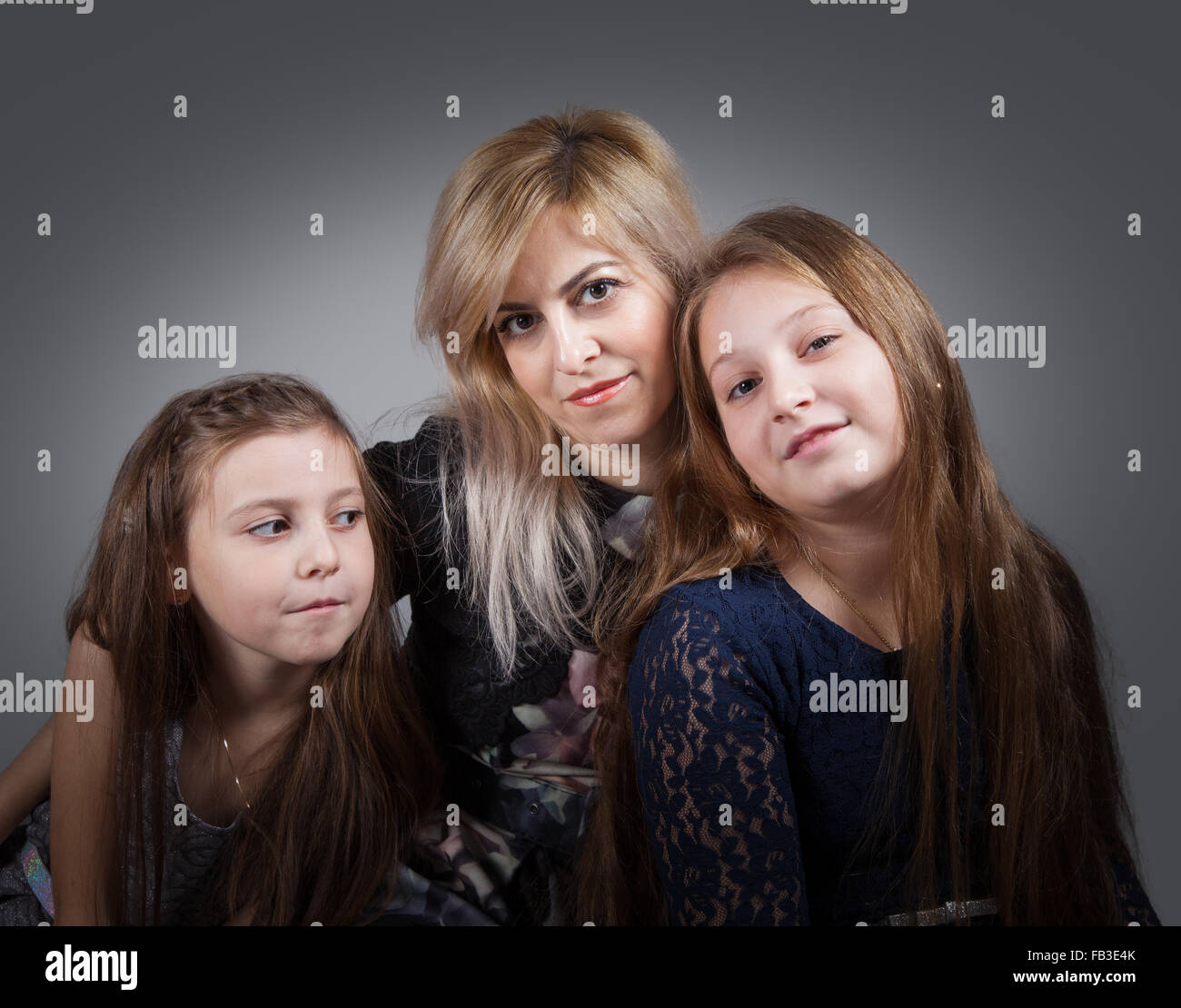 Portrait of a beautiful mother with her 2 daughters, studio shot Stock ...