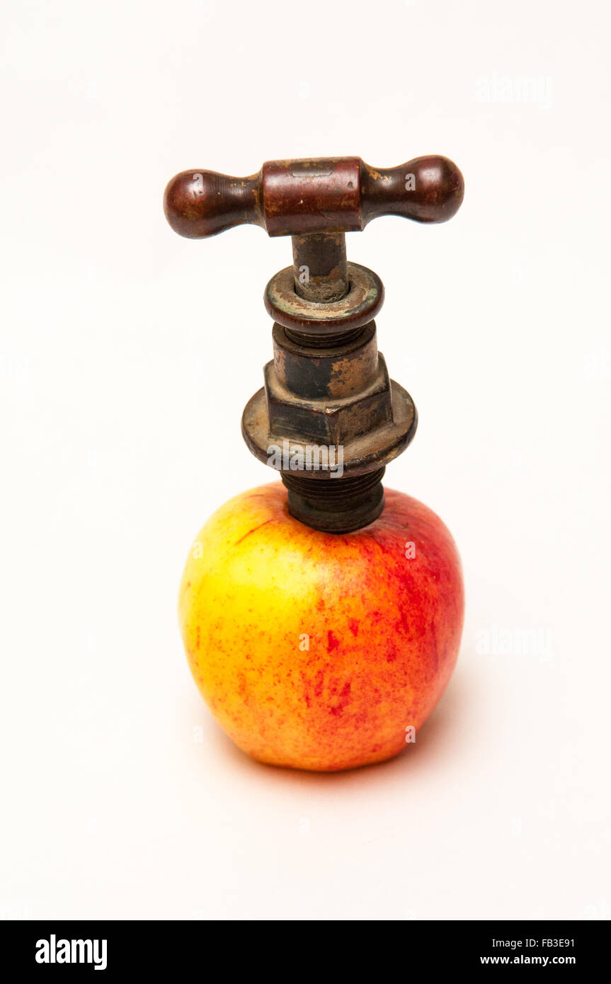 Old style tap in an apple Stock Photo - Alamy