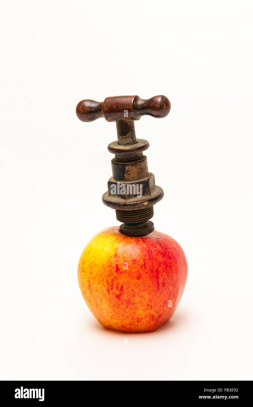 Old style tap in an apple Stock Photo - Alamy